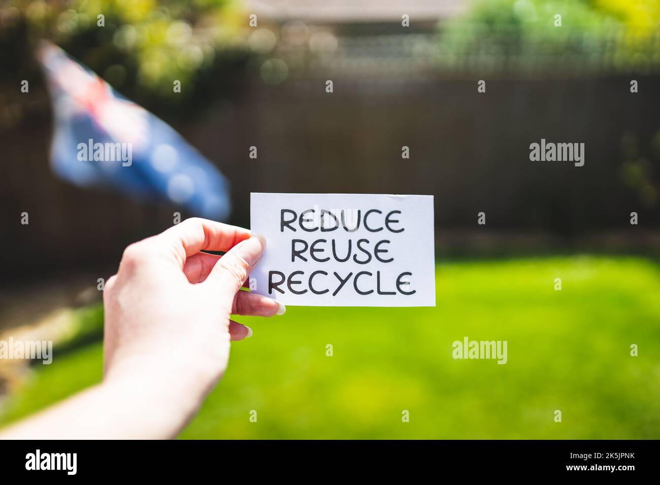 reduce reuse recycle sign in front of backyard bokeh with Australian ...