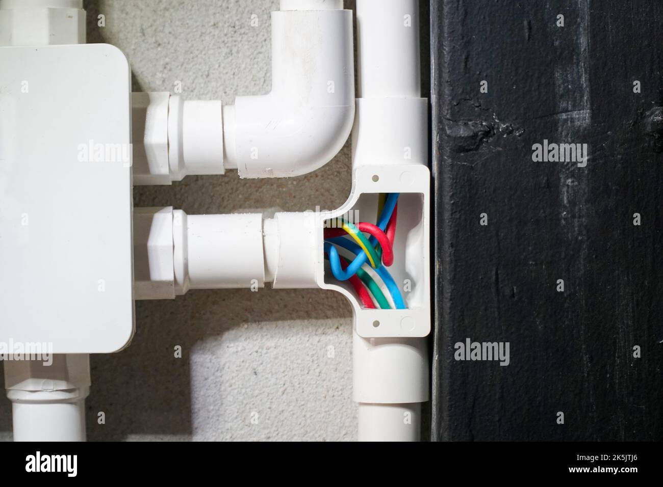Electrician open cap of PVC inspection tee fitting on wall Stock Photo ...