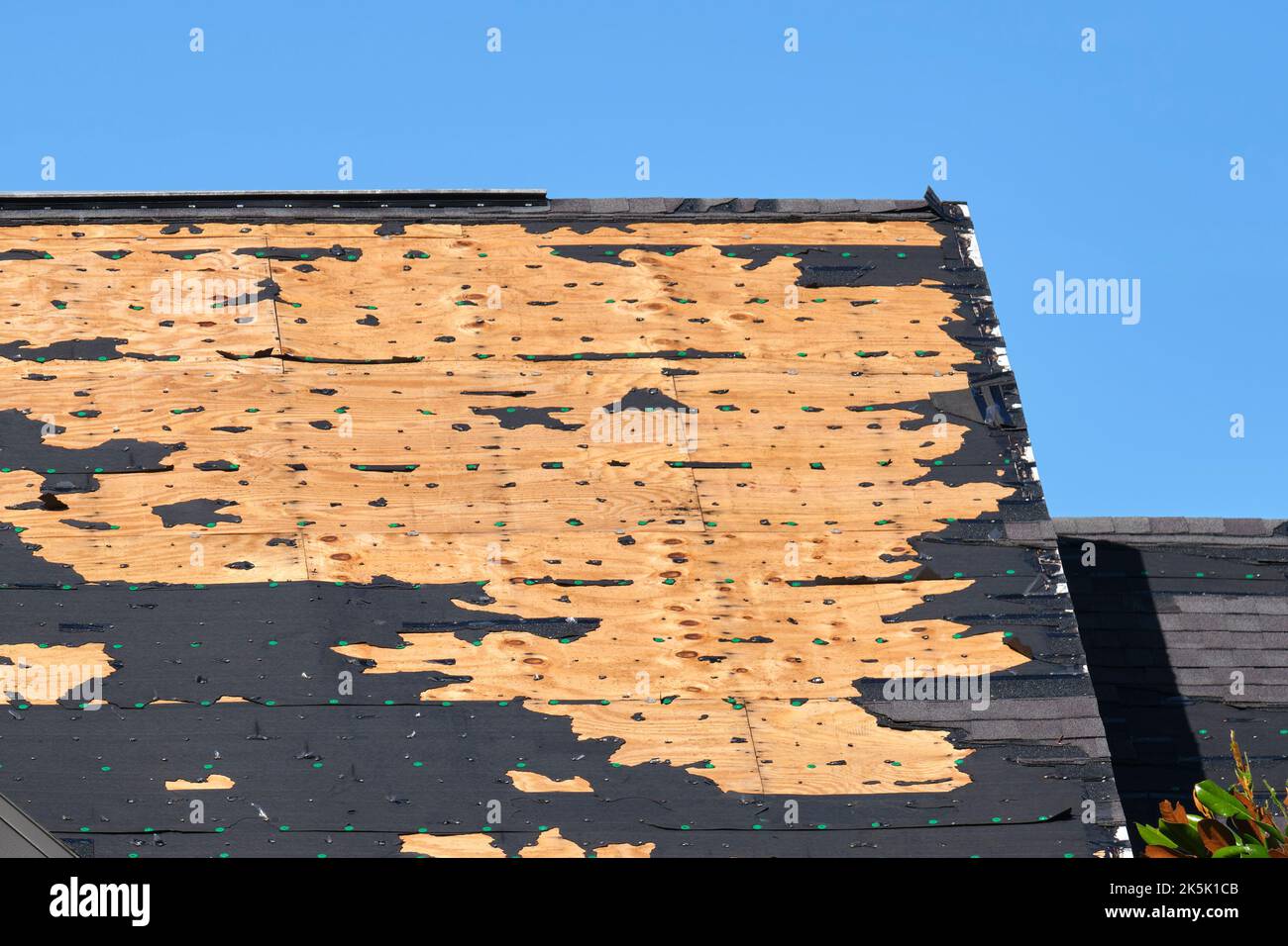 Damaged house roof with missing shingles after hurricane Ian in Florida ...