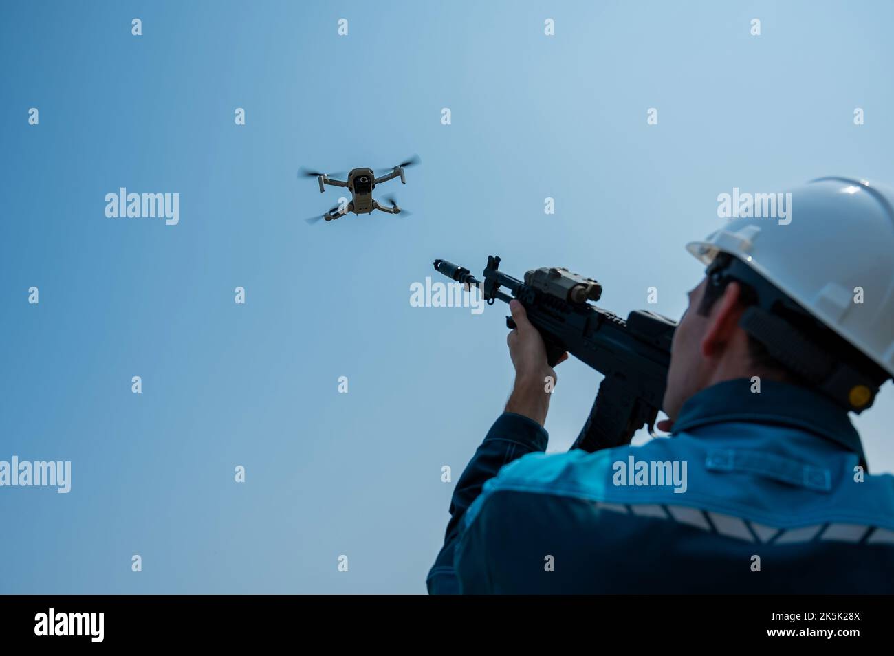 Caucasian man in a helmet shoots a flying drone with a rifle Stock ...