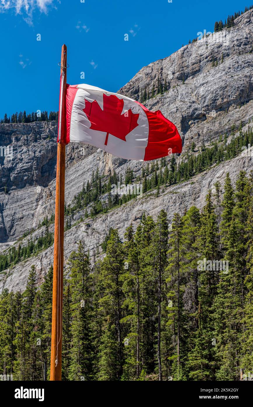 Canadian Flag waving over the mountains of Banff National Park, Canada ...