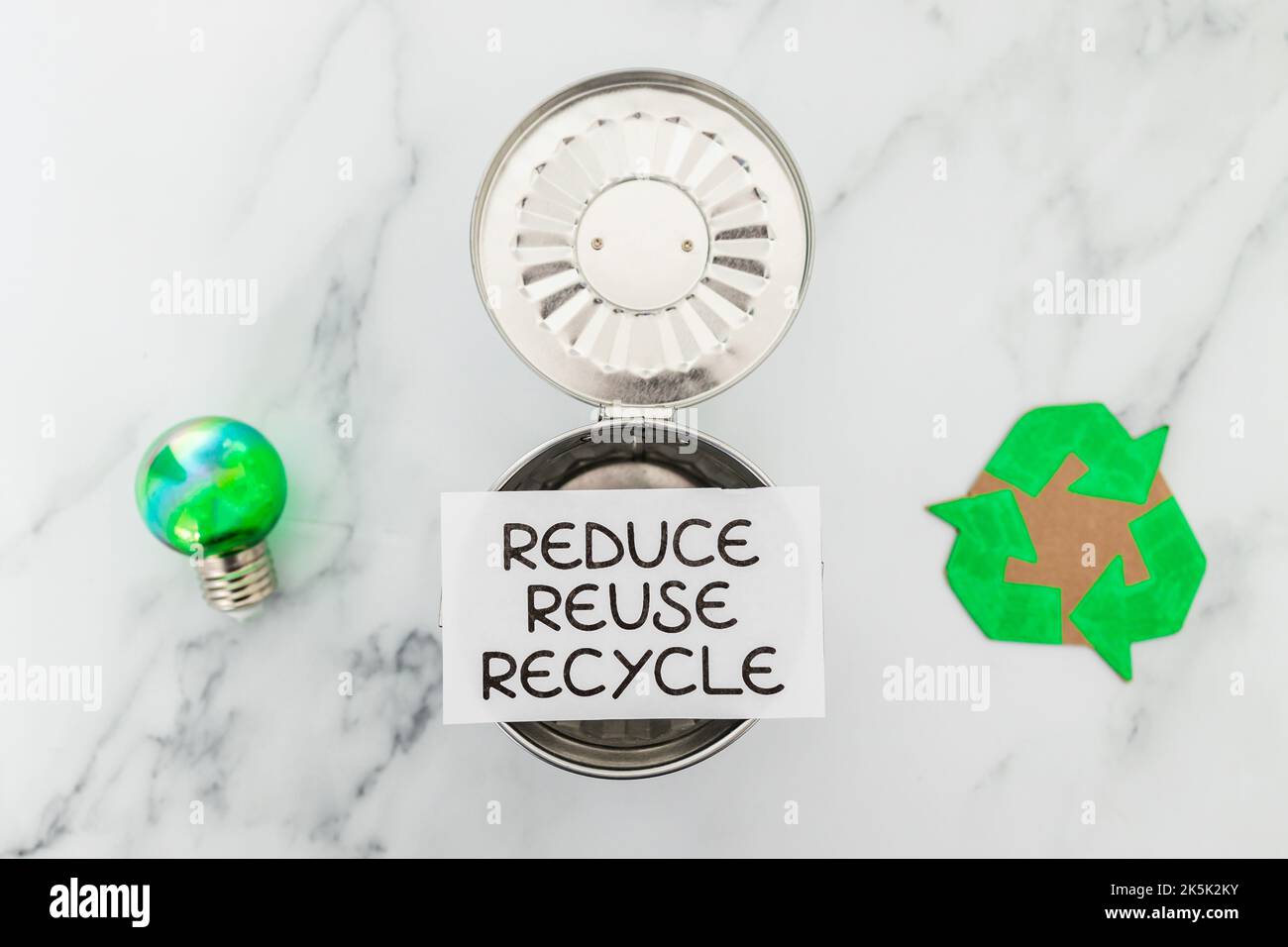 reduce reuse recycle sign with mini trash can next to green light bulb ...
