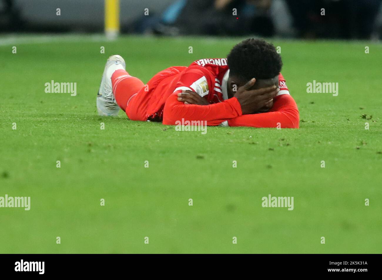 Alphonso Davies of Bayern Muenchen liegt verletzt am Boden Borussia ...