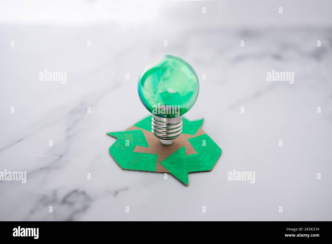 recycle sign with green light bulb standing on it, concept of ...