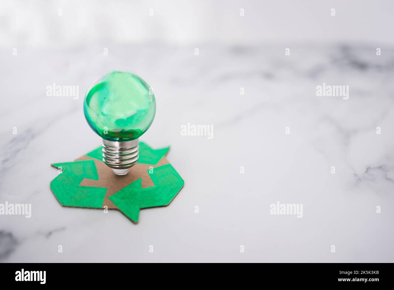 recycle sign with green light bulb standing on it, concept of ...