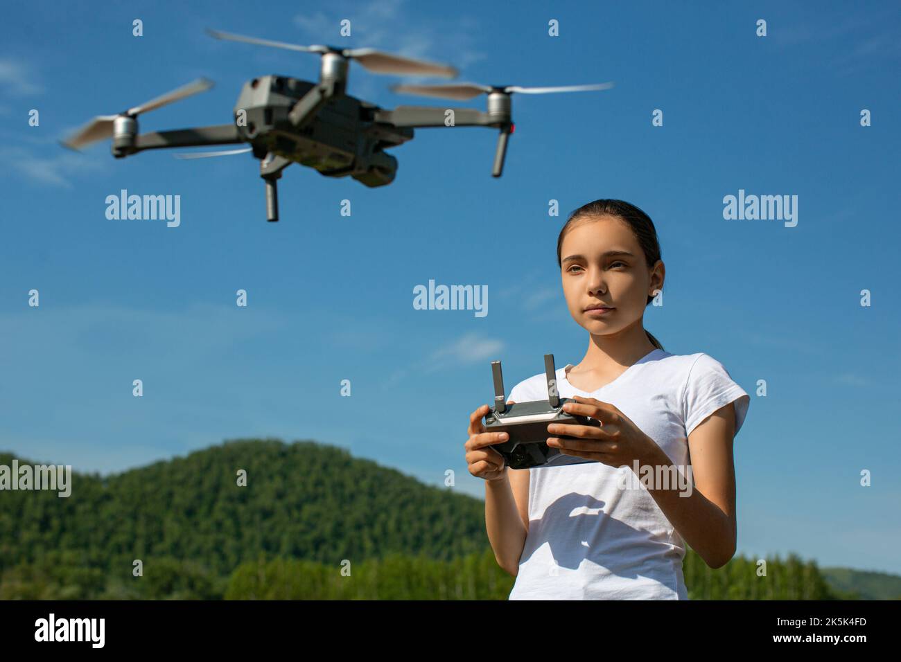 A teenage girl controls a drone on a sunny summer day outdoor Stock ...
