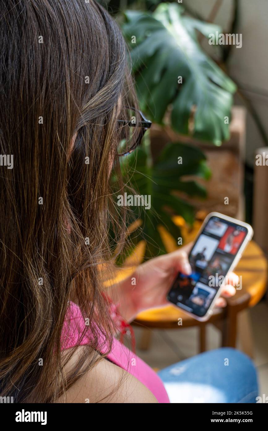 Happy millennial hispanic teen girl checking social media holding ...