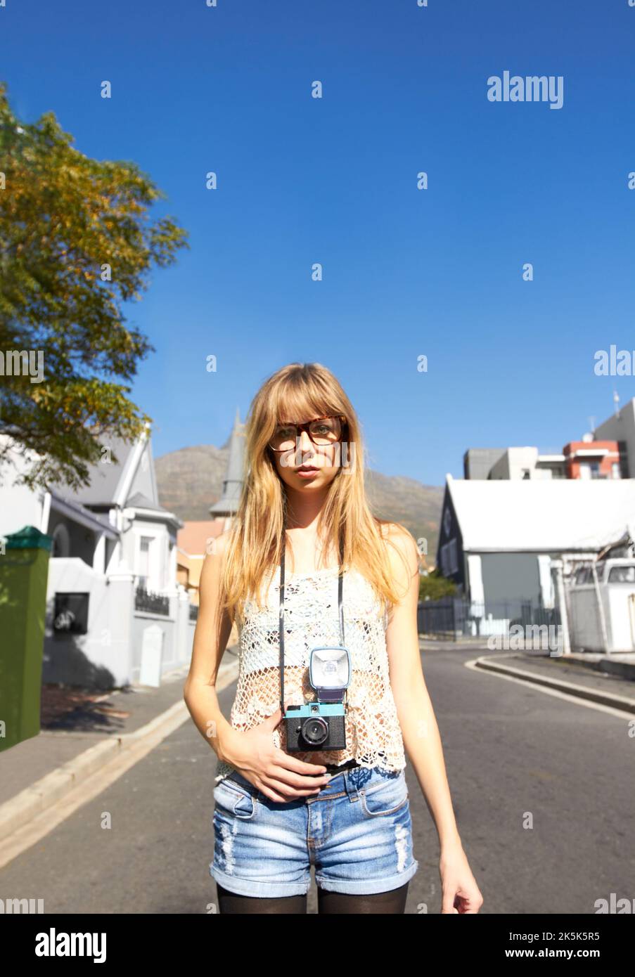 Quaint, urban style. A stylish young girl with a vintage camera ...