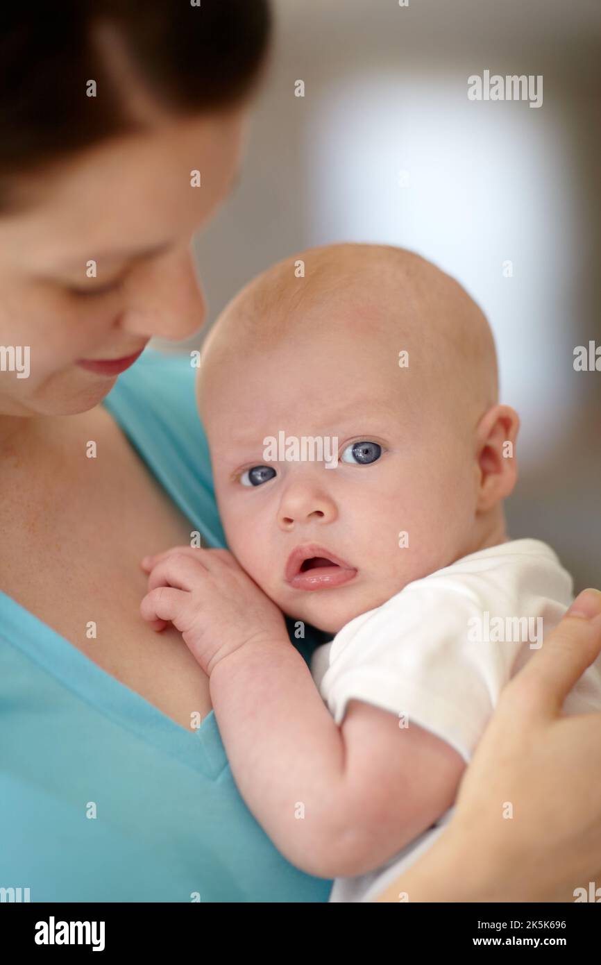 Turn away, I want some milk. Young beautiful mother holding her cute ...