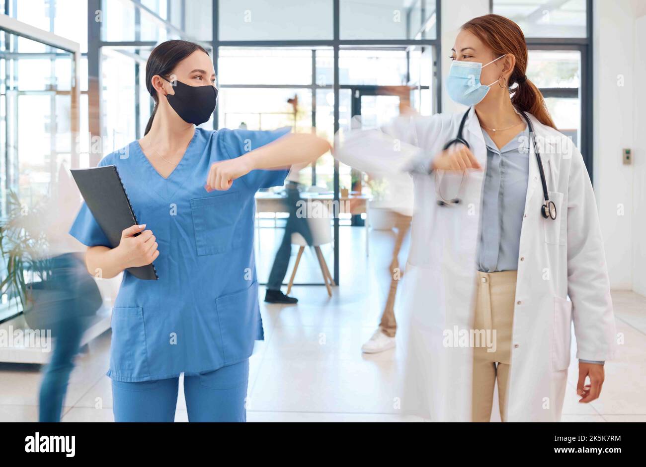 Covid healthcare doctor and nurse greeting with elbow in hospital ...