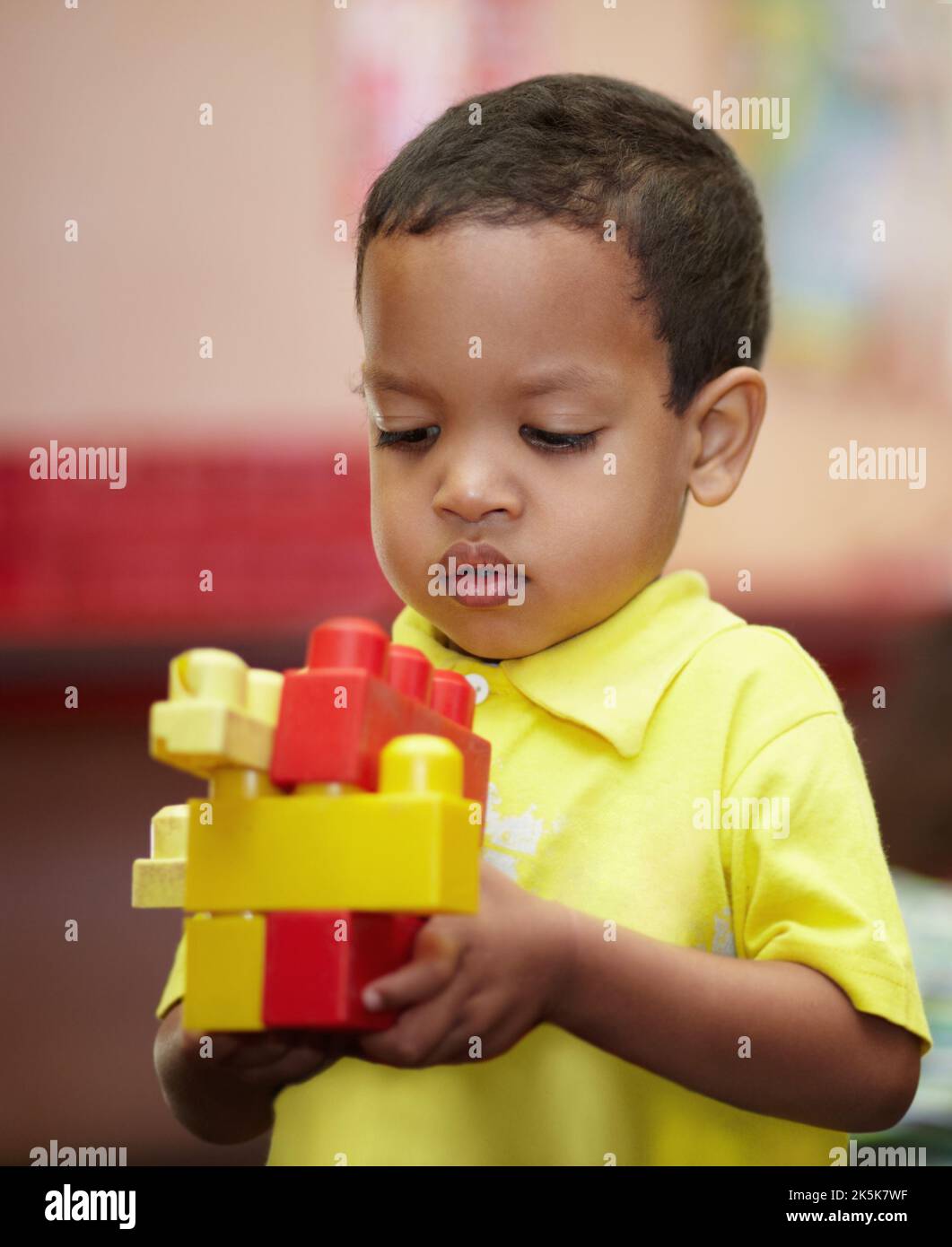 Concentration is key. A little ethnic boy concentrating on his plastic ...
