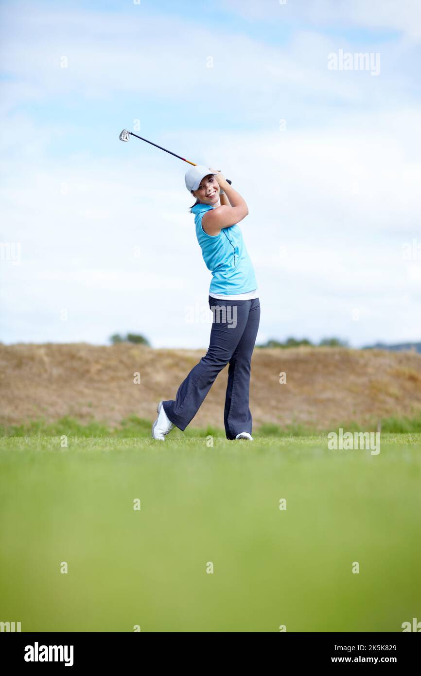 A swing of a professional. A young woman following through after ...