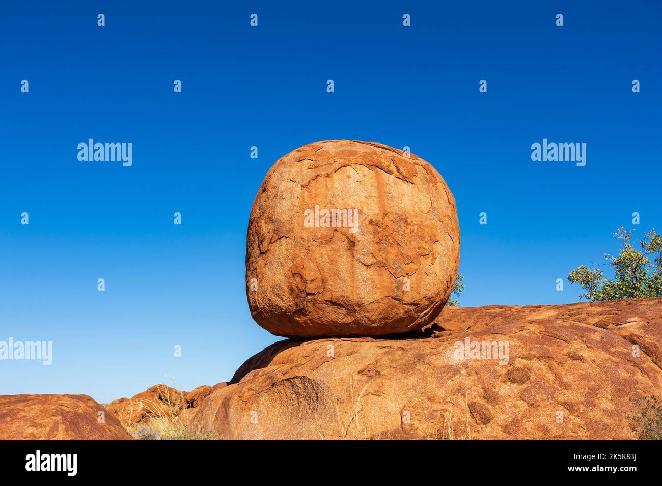 Balanced round eroded granite boulder at Devil's Marbles, a popular ...