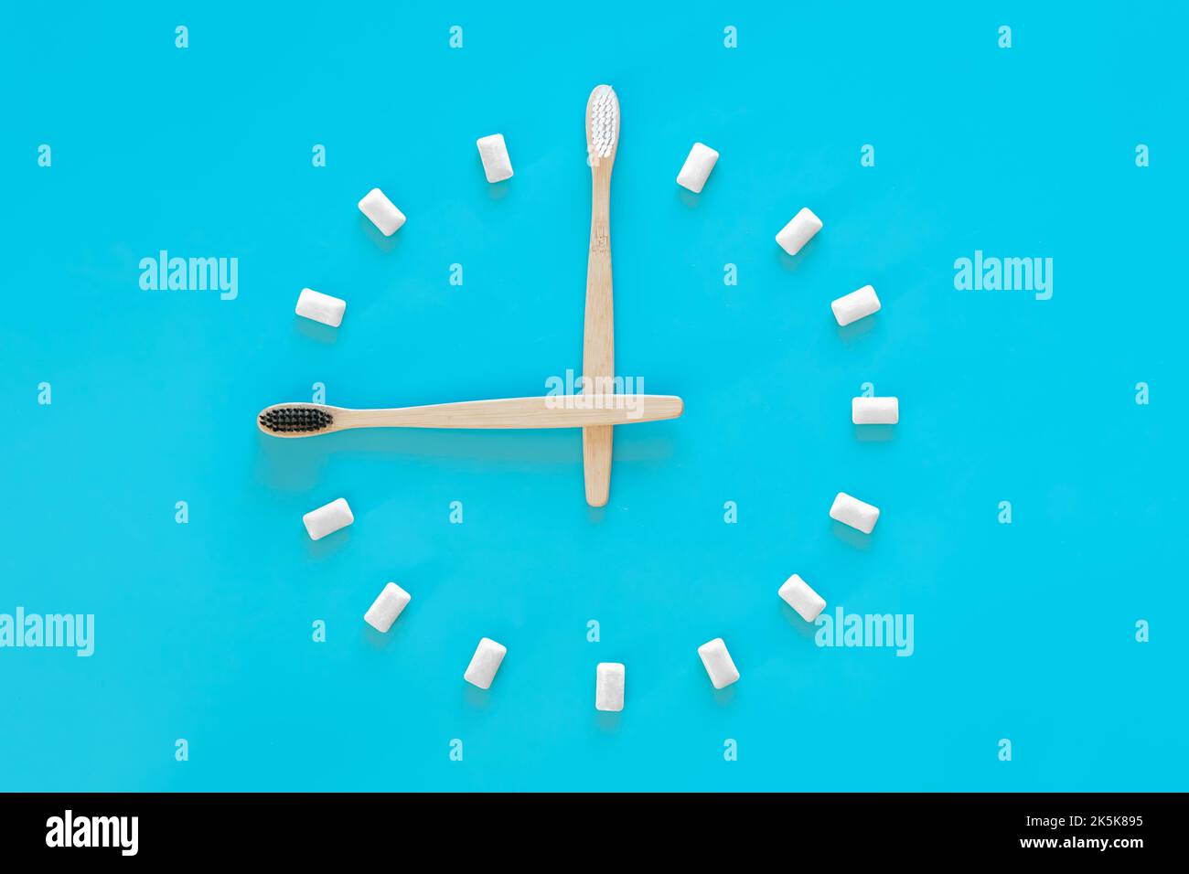 Flat lay, a clock made of chewing gum on a blue background and a ...