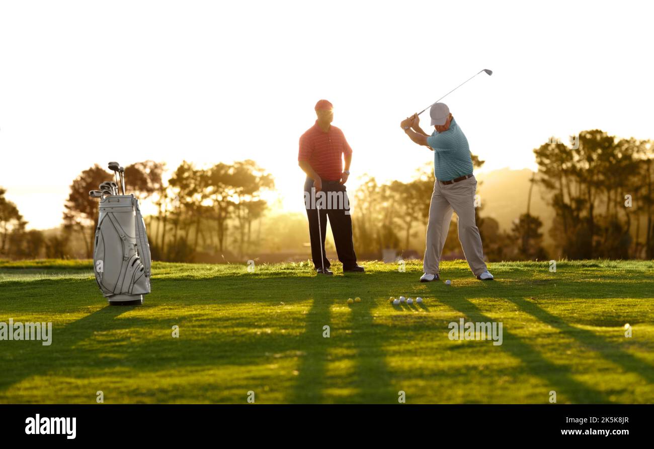 Showing him how its done. Two male golfers playing a round of golf ...