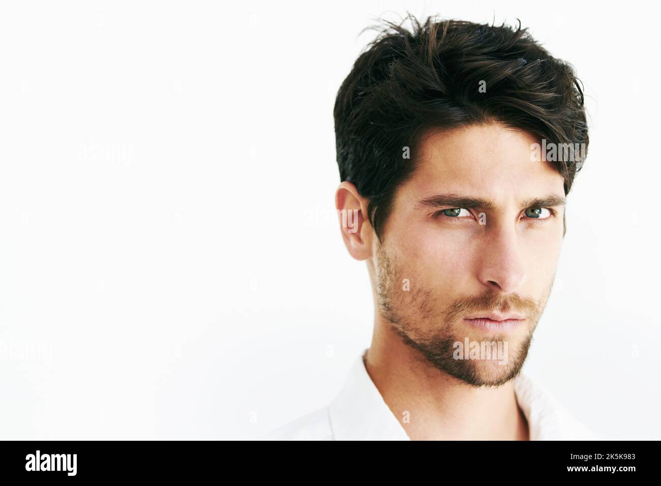 Weary eyes. Closeup portrait of a serious male staring at the camera ...