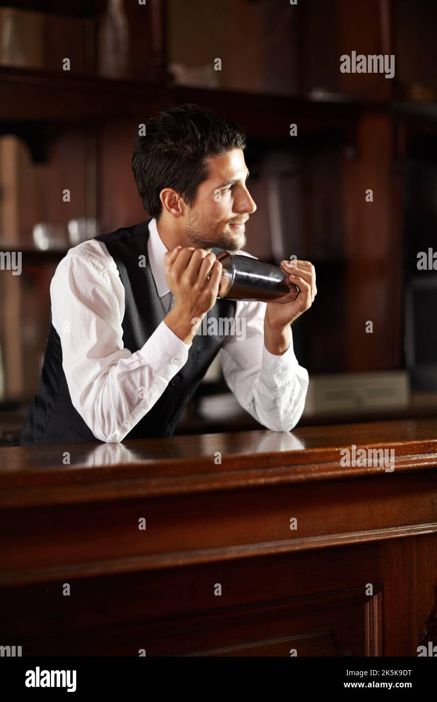Getting ready for the after work rush. A handsome young bartender ...