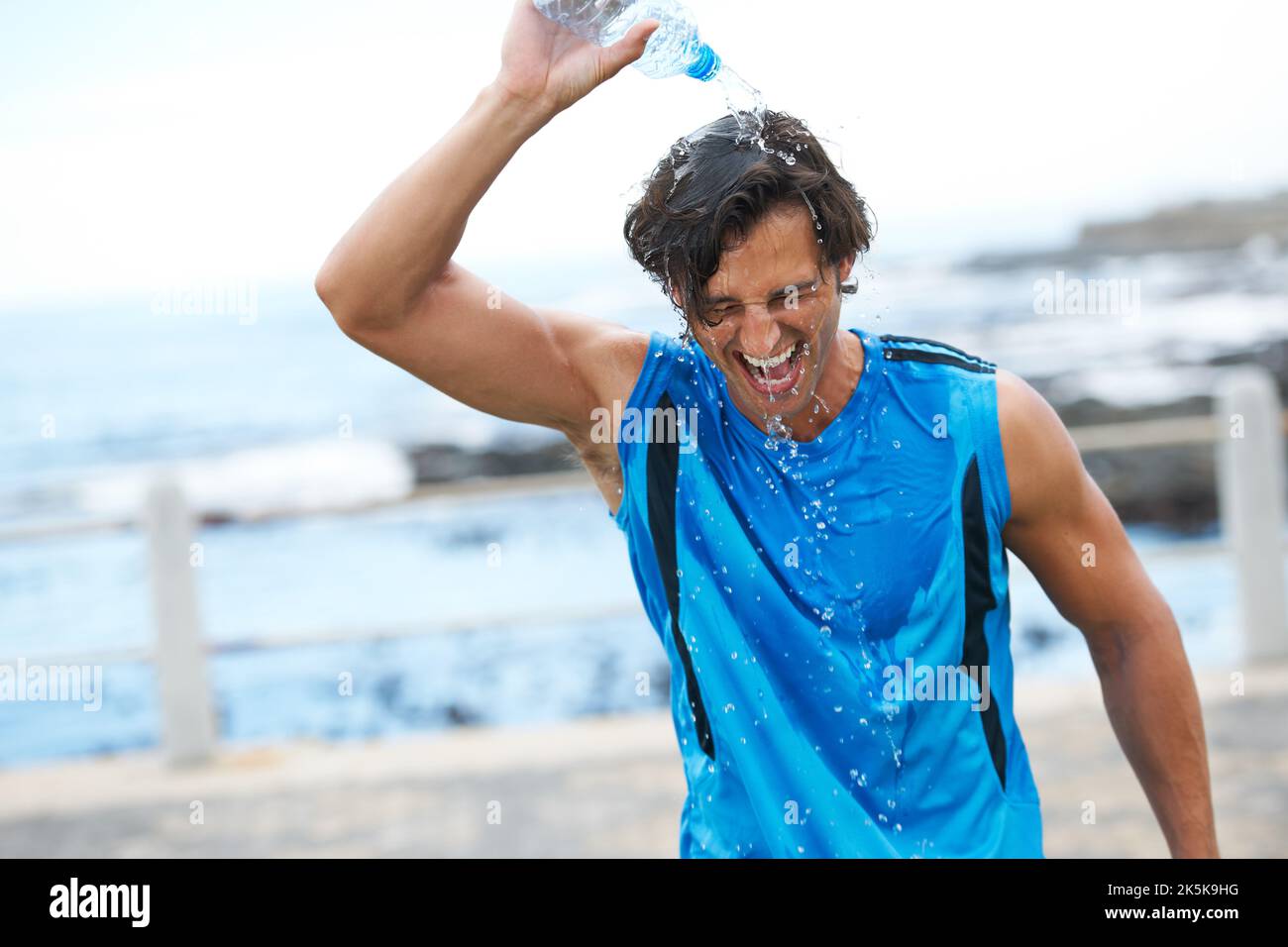 Revitalize your body with a splash of water. An ecstatic young male ...