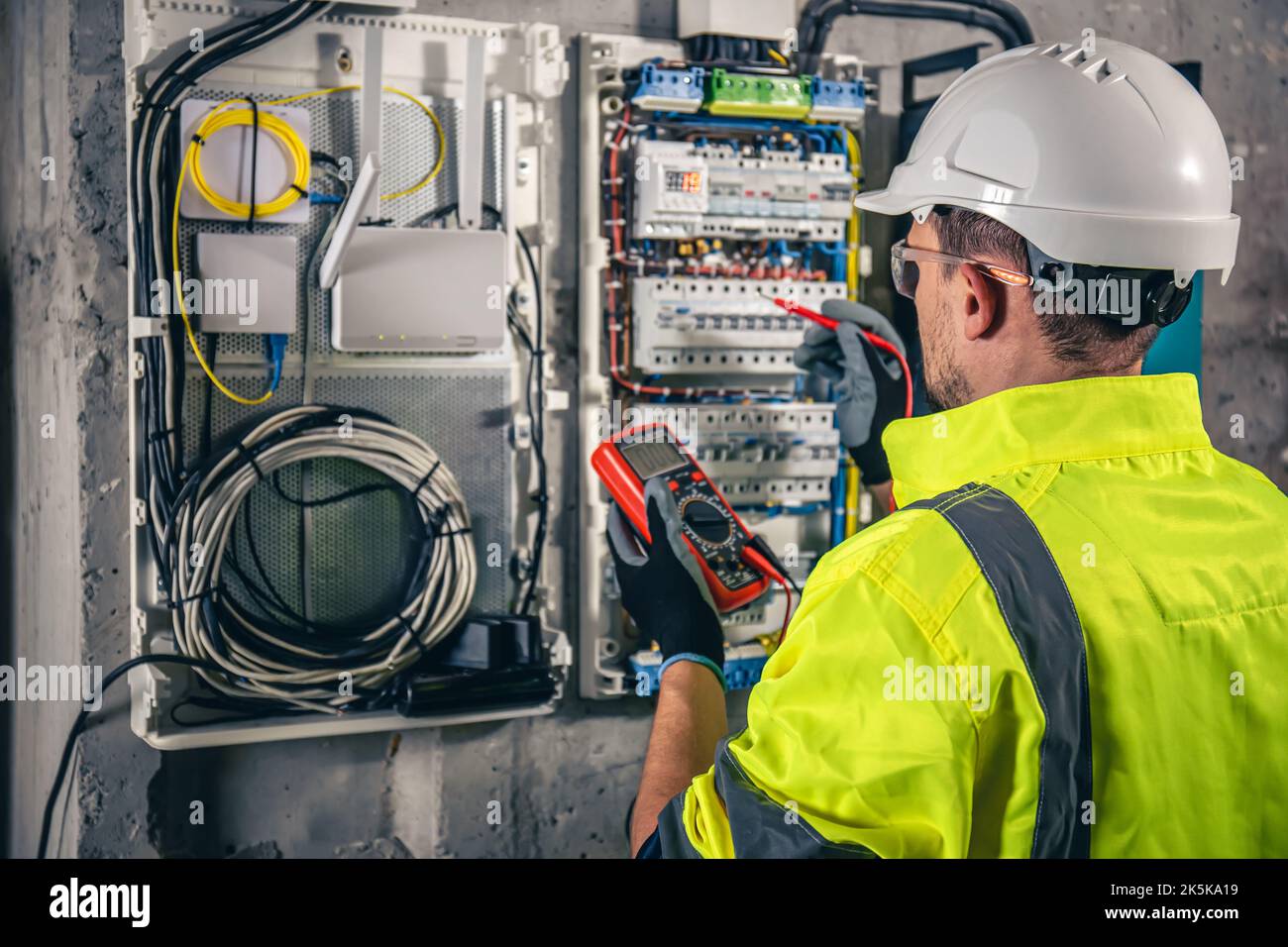 Man, an electrical technician working in a switchboard with fuses Stock ...