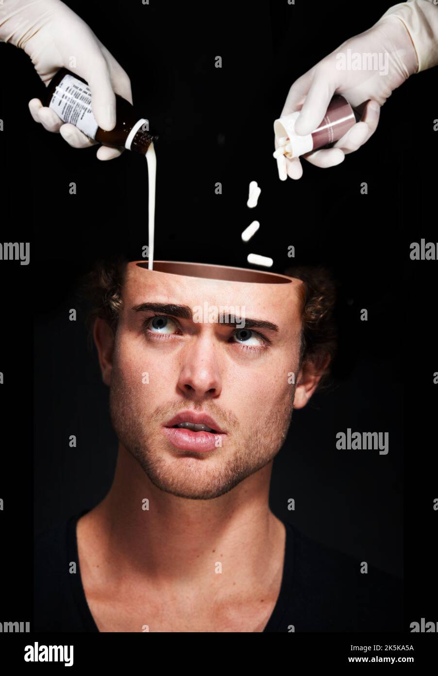 Medicine for the mind. Two hands pouring medicine into the open head of ...