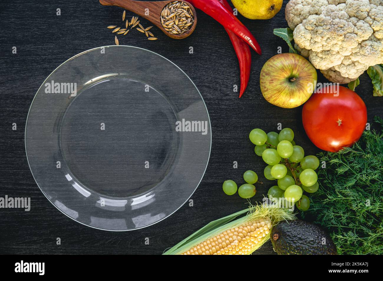 Vegetables on black background, flat lay composition with empty plate ...