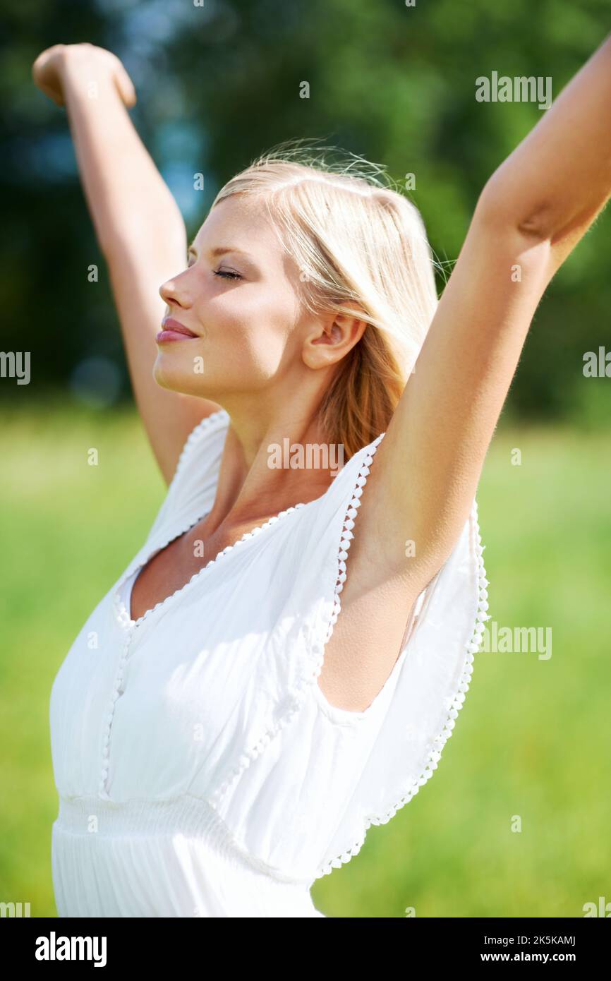 Taking a deep breath and letting it all go. Lovely young woman standing ...