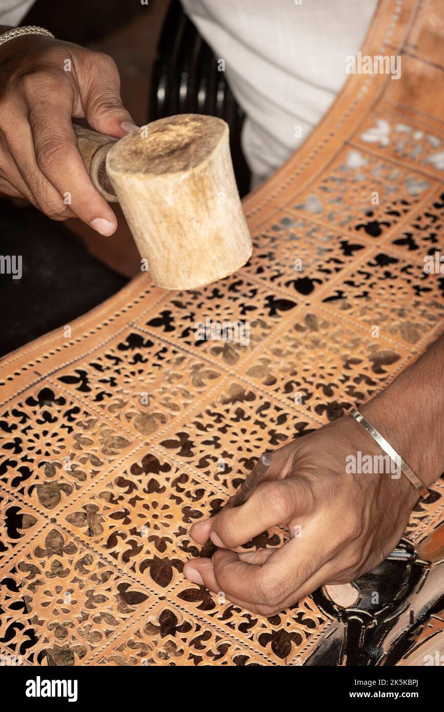 craft artist making traditional buffalo leather carving art in ...