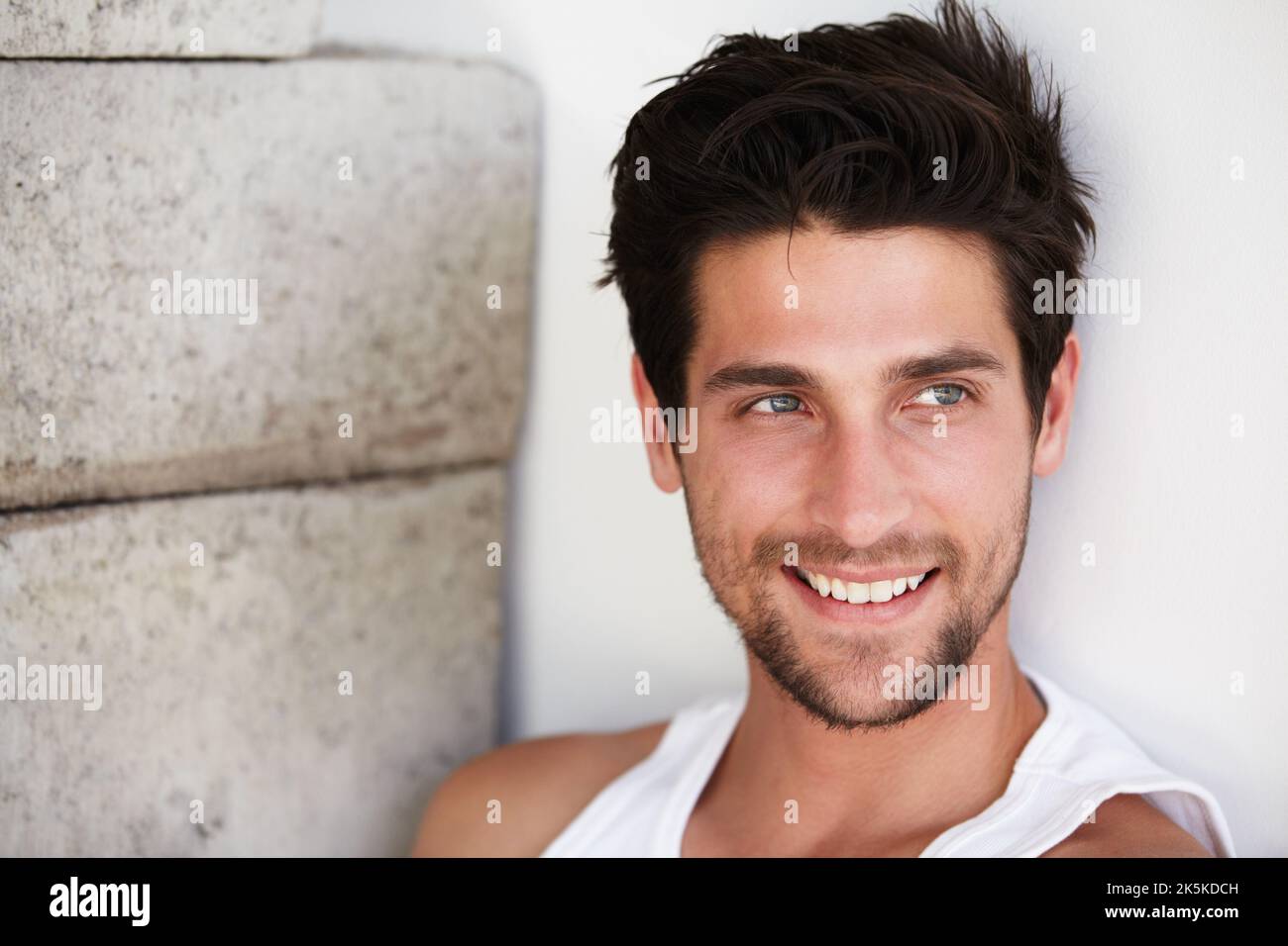 His smile will make you stare. Good-looking young male looking away ...