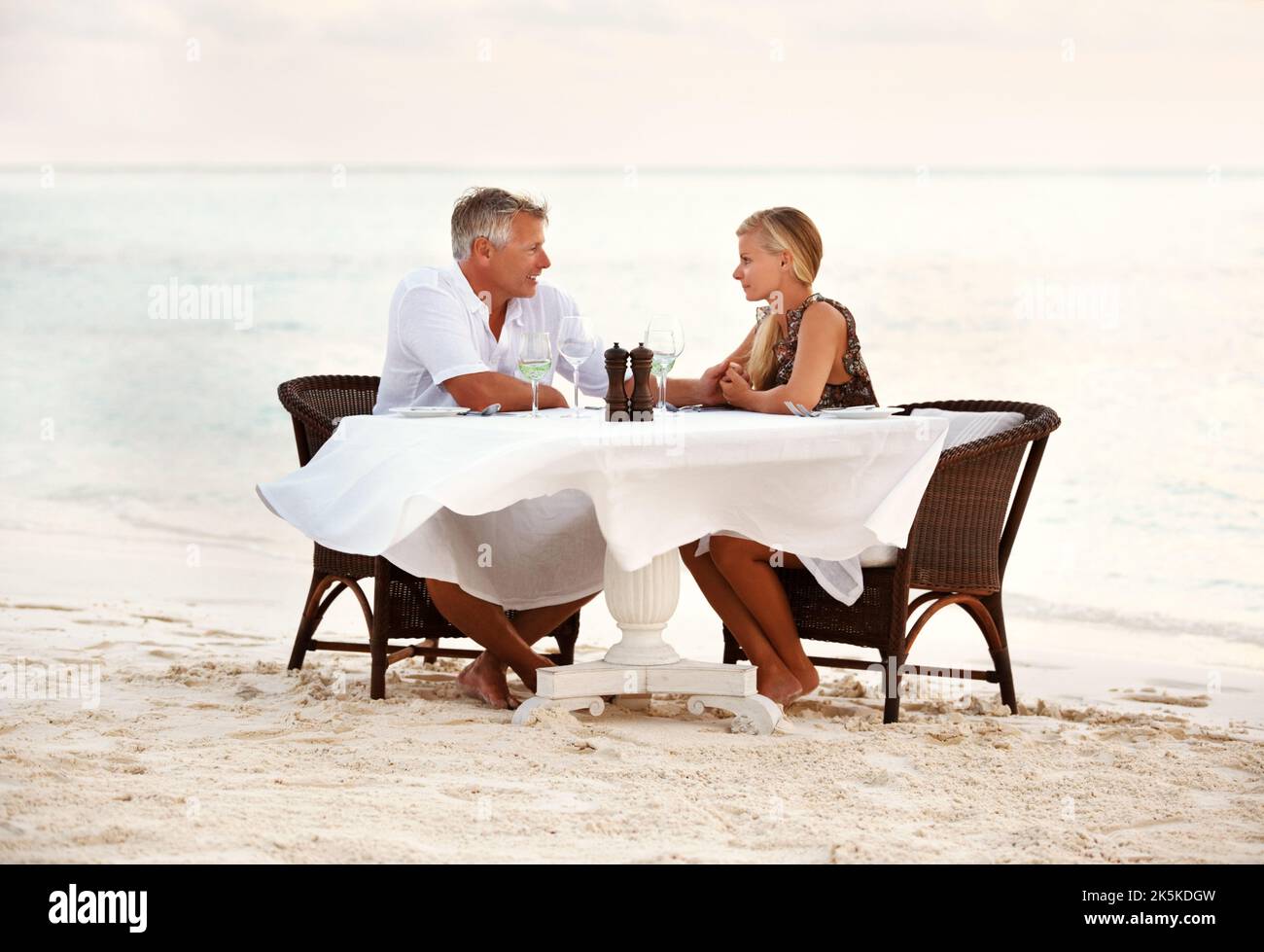 Lovely mature couple sitting at the seaside dinning table. a mature couple enjoying a romantic ...