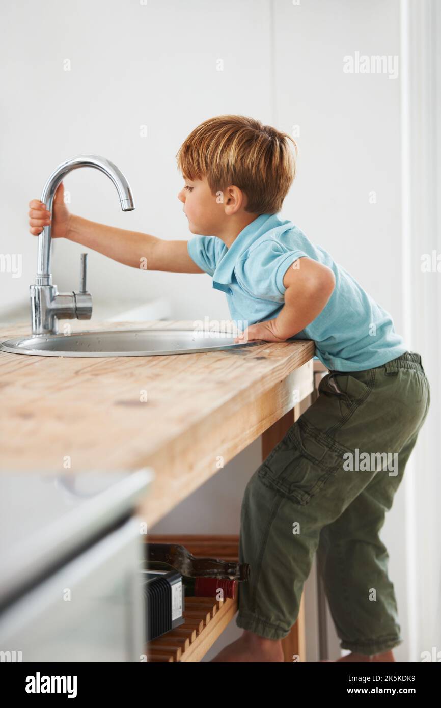 I want to get some water...A cute young boy climbing the kitchen ...