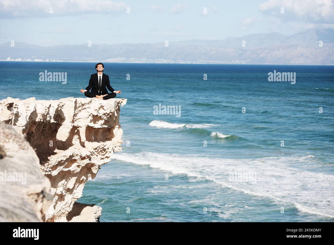 Finding enlightenment in nature. Businessman sitting and meditating on ...