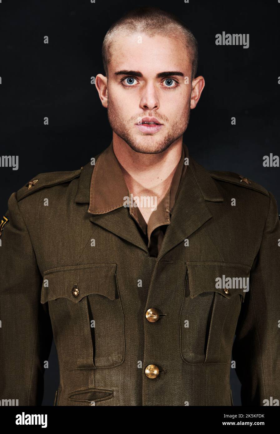 Standing at attention. Portrait of a young man in a military uniform ...