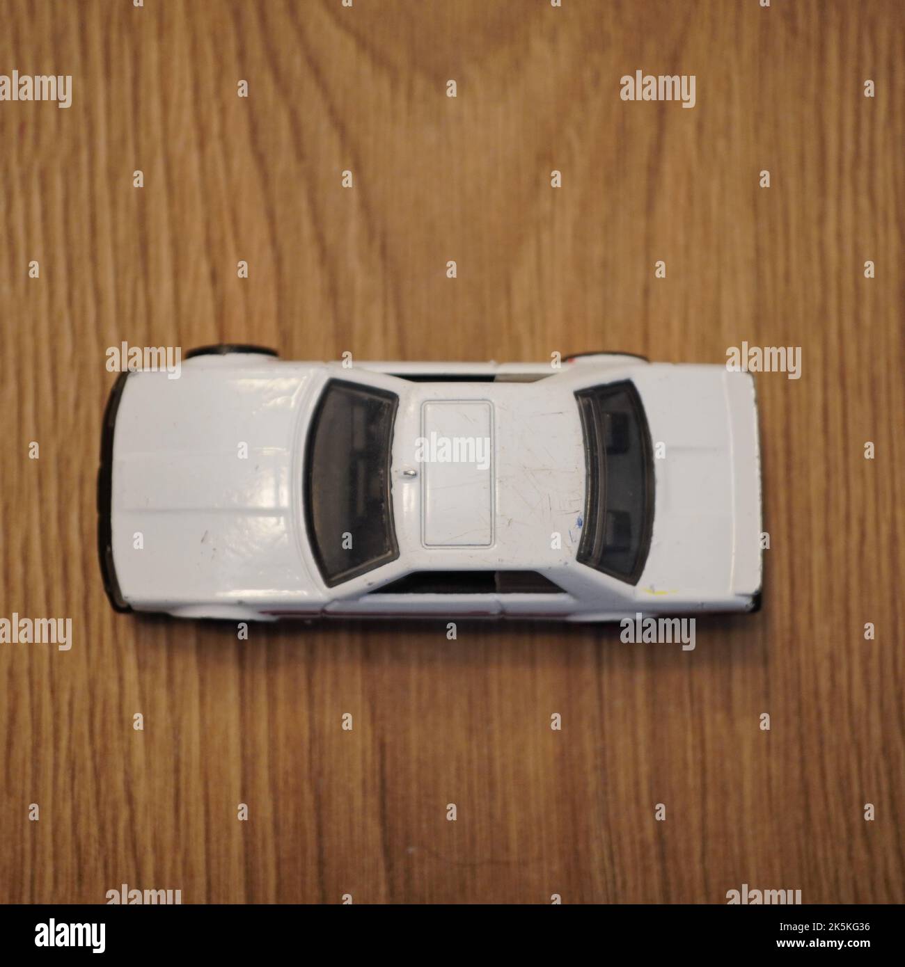The top view of a white Mattel Hot Wheels toy car on a wooden surface ...