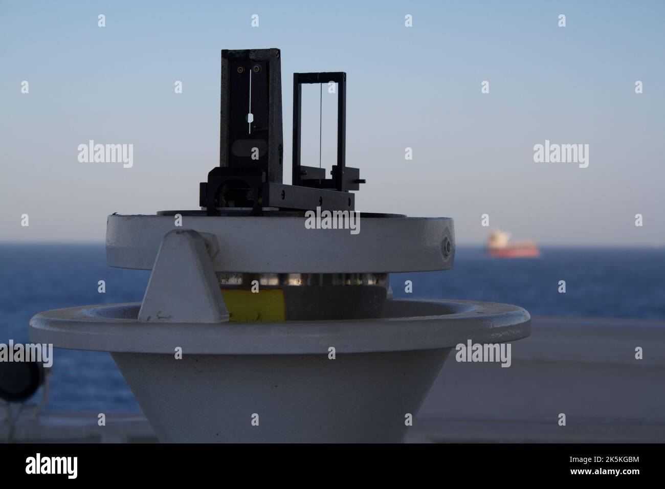 View of a merchant ship from the bridge wings of another ship at sea with a gyro compass and ...