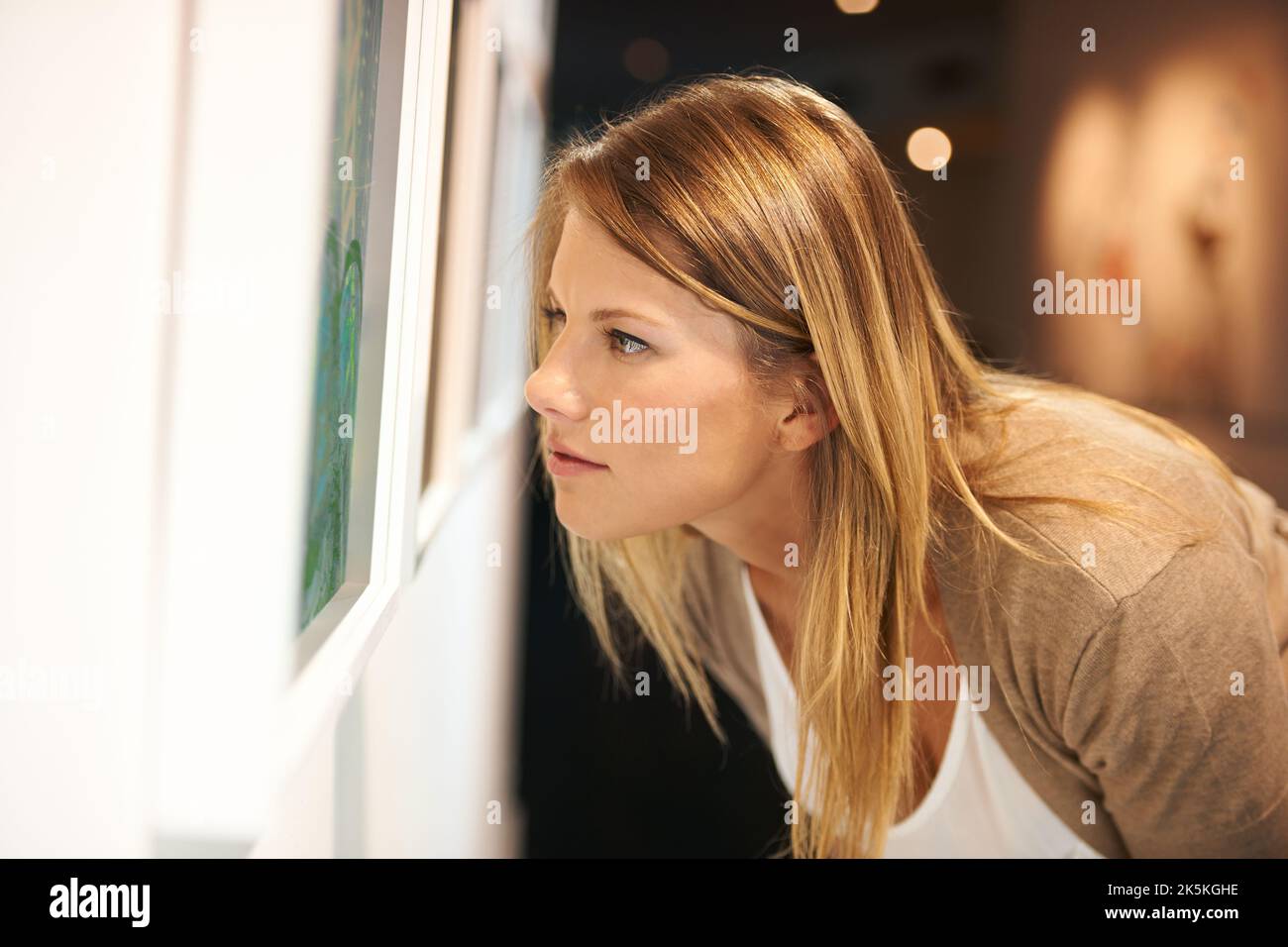 Taking in a century of art. a young woman examining paintings in a ...
