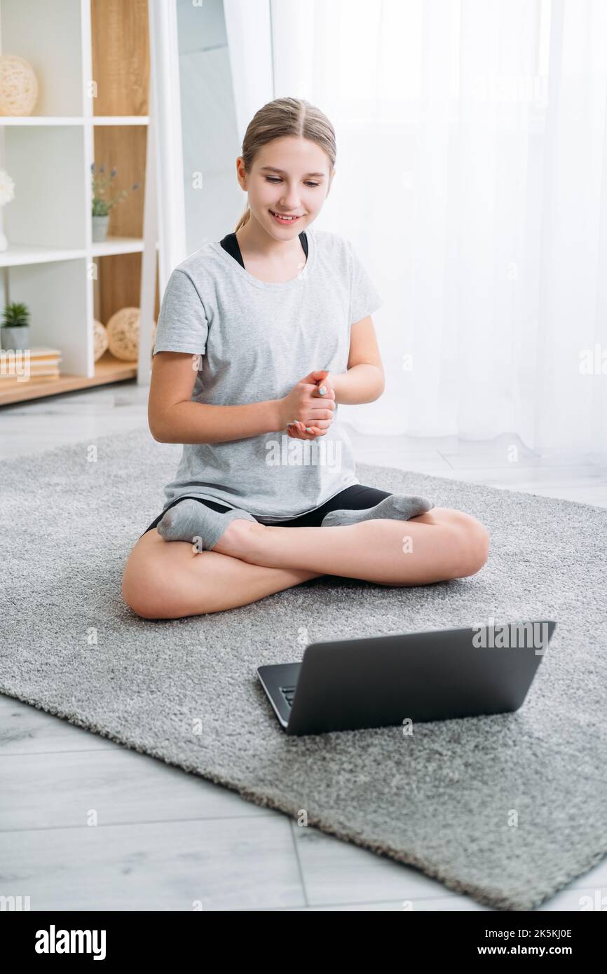 yoga online for kids home exercise girl laptop Stock Photo - Alamy