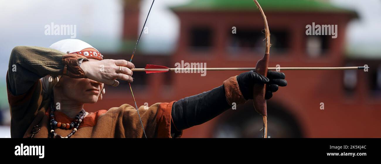 Medieval archery tournament. A woman shoots an arrow in the medieval ...