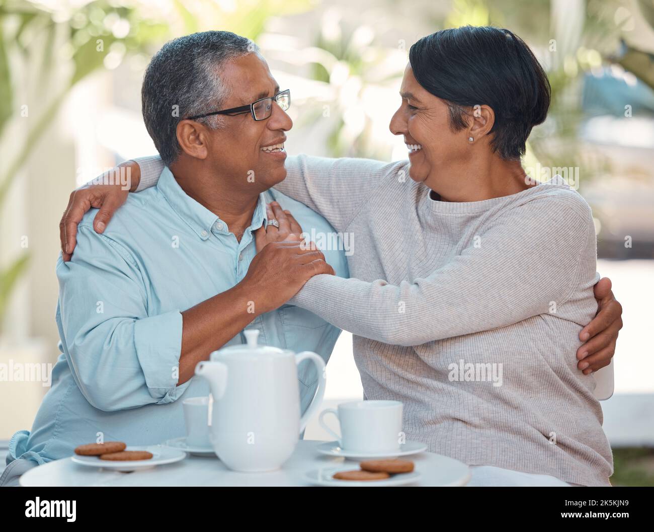Senior couple laughing, drinking coffee and bonding in backyard cafe ...