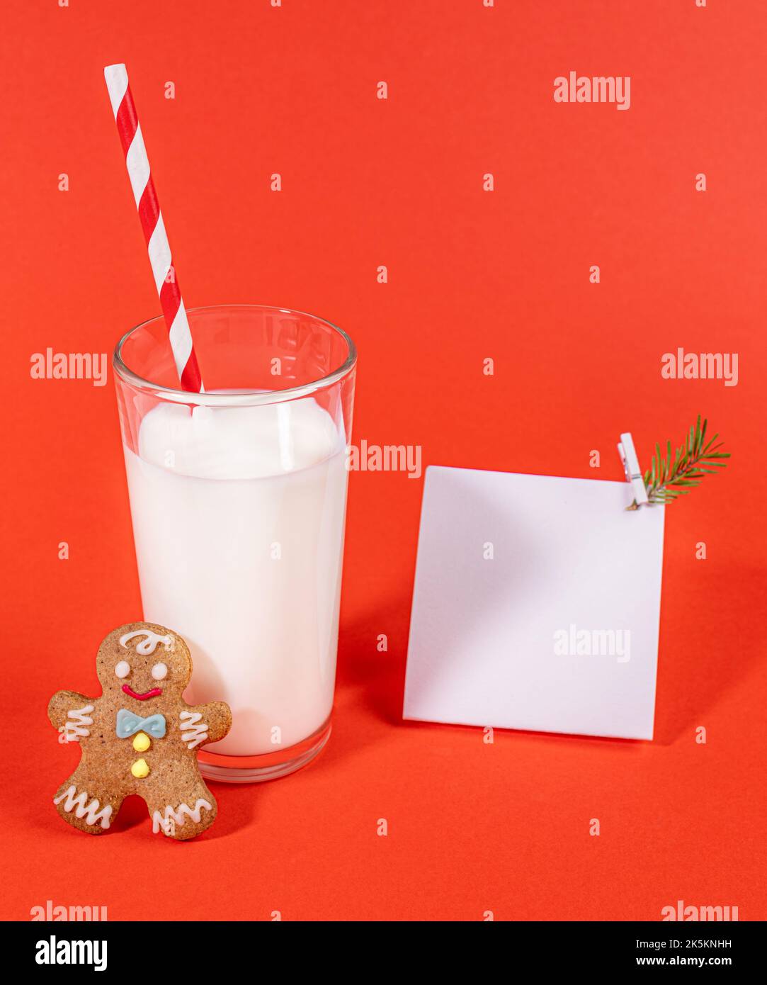 Milk glass with drinking straw, gingerbread man and empty white note on ...
