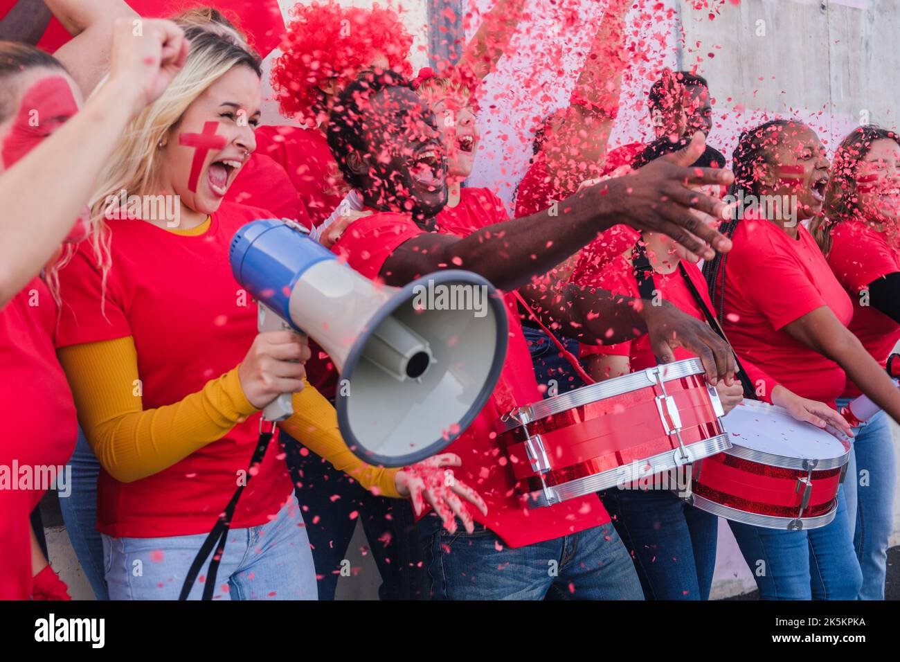 Group of fans of a team cheering with great joy and using confetti ...