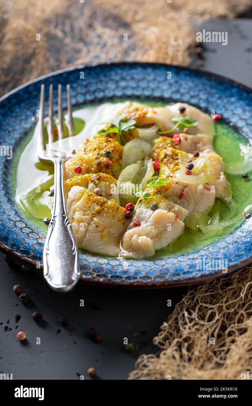 Healthy marinated herring on blue plate and fishing net. Herring ...