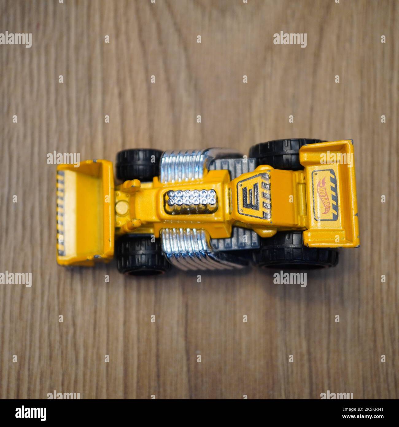 The top view of a yellow Mattel Hot Wheels toy car on a wooden surface ...