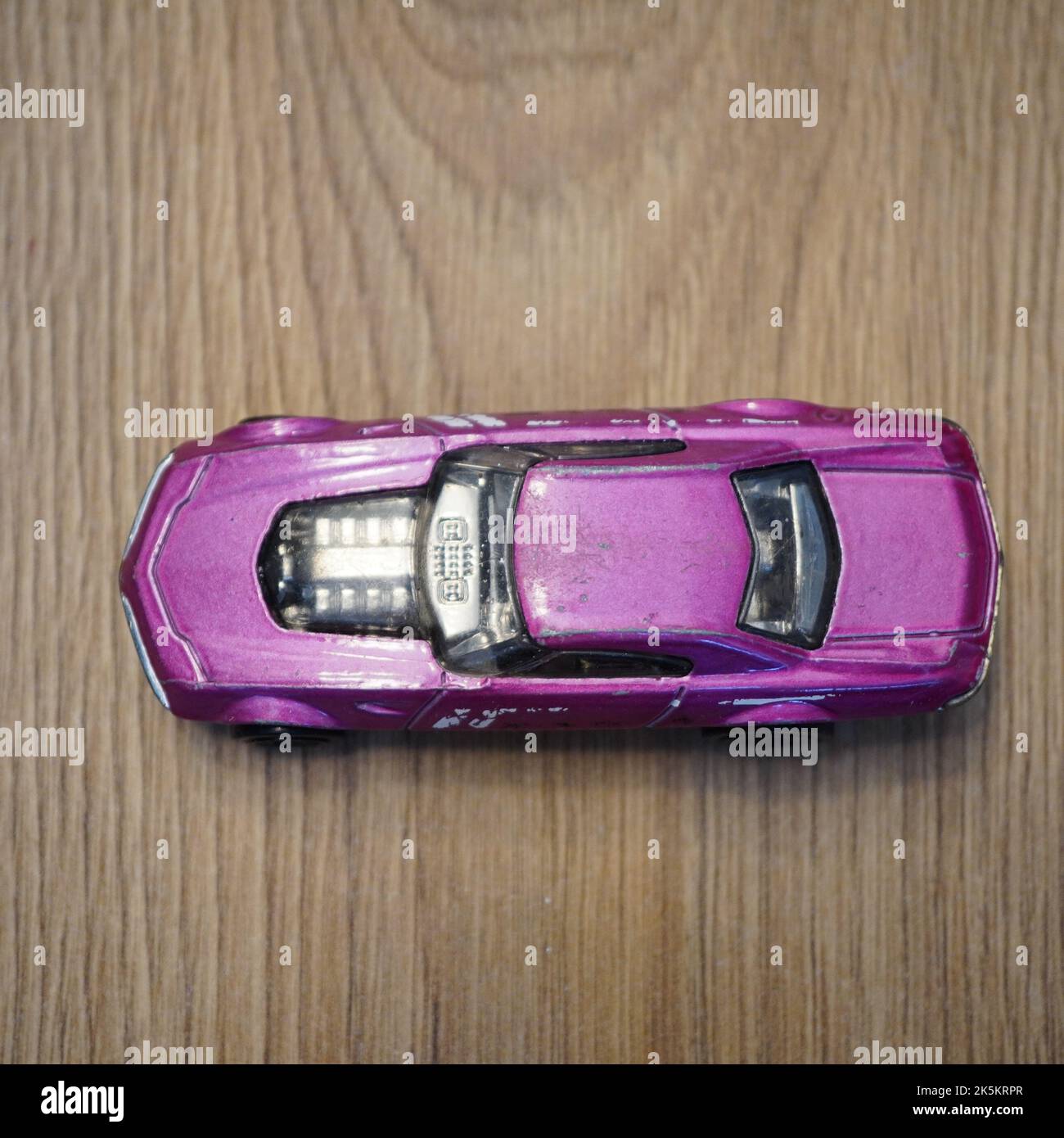 The top view of a purple Mattel Hot Wheels toy car on a wooden surface ...