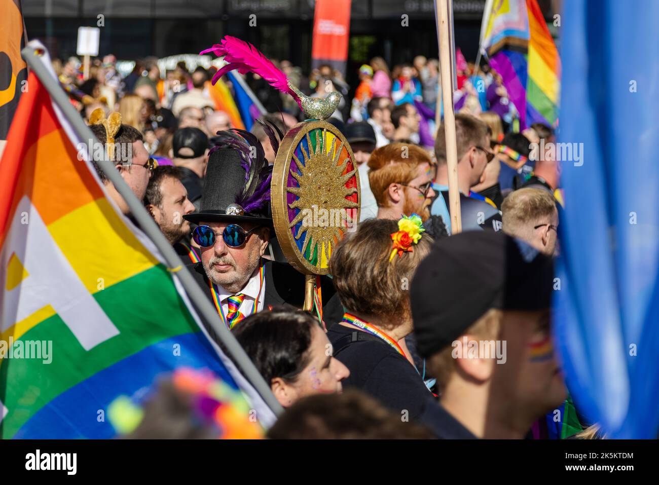 A distinguished looking gentleman carries a banner through the crowd at ...