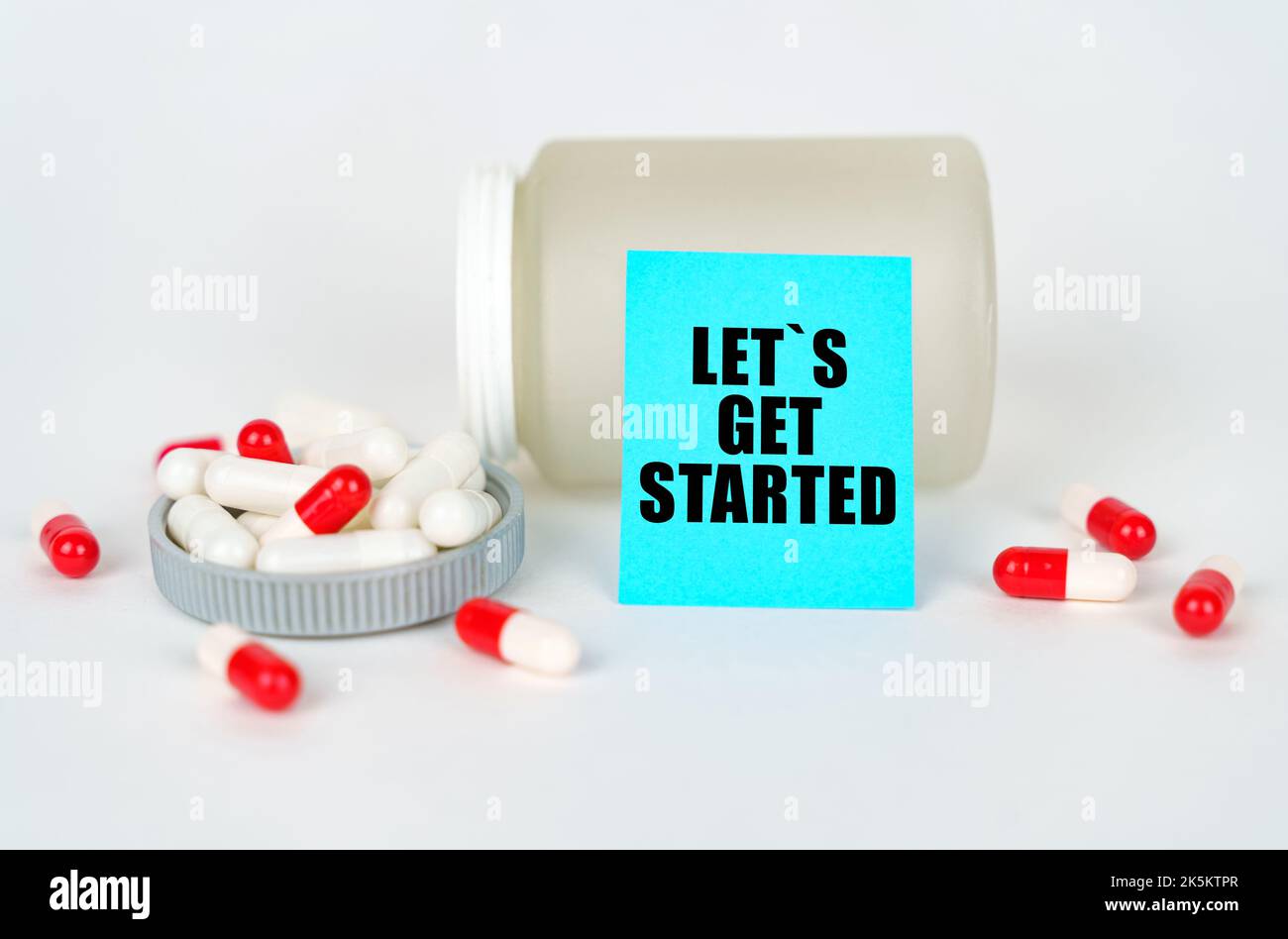Medical concept. On a gray background, a jar, capsules and a sign with ...