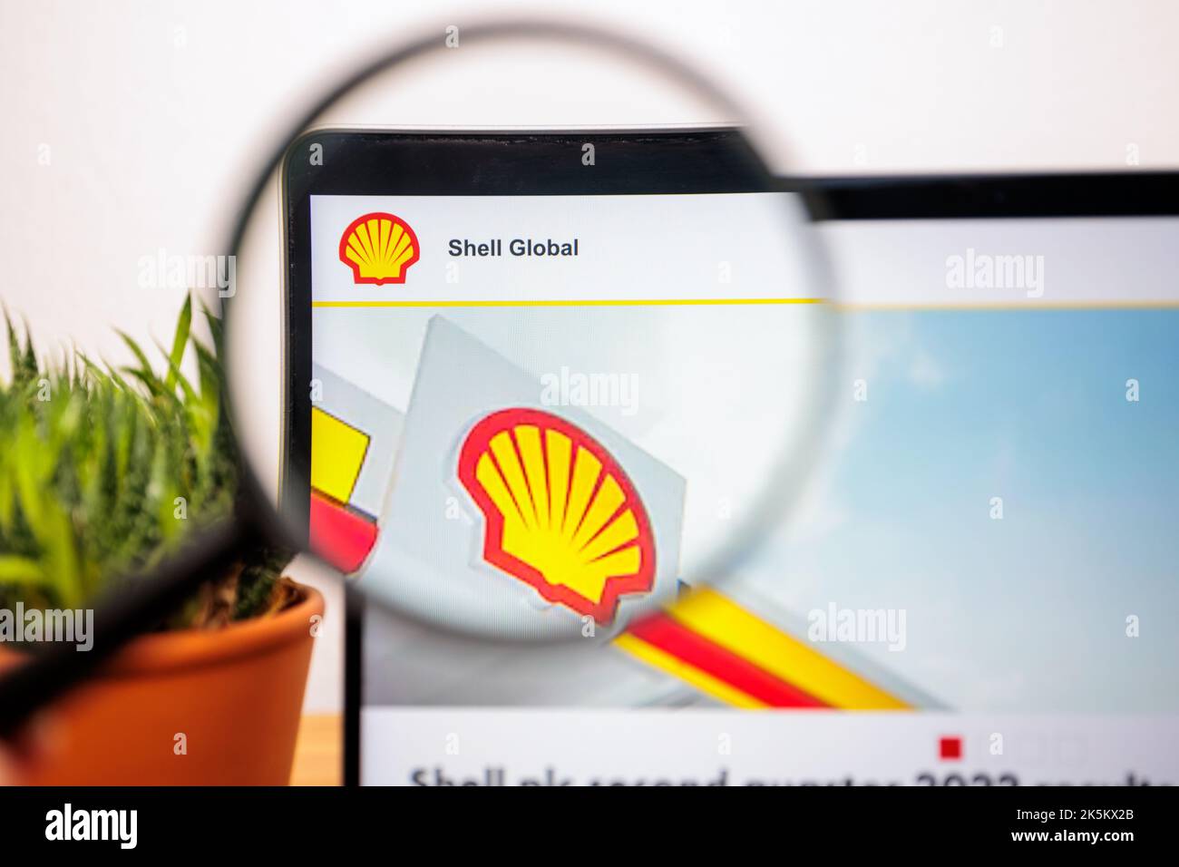 A display of the Shell website on a laptop screen and the Shell logo ...
