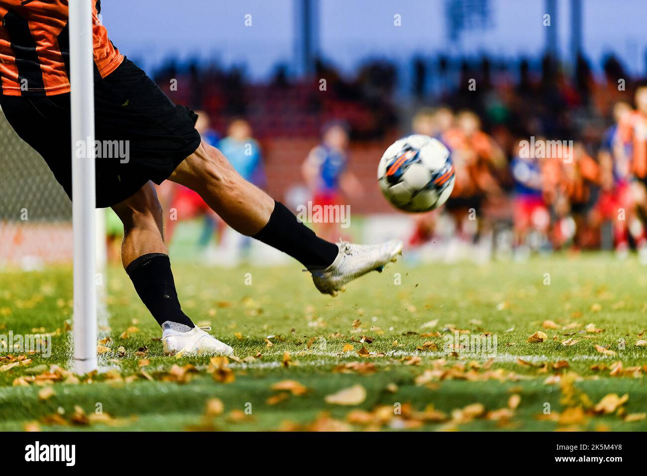 Footballer takes the corner. Detail of player's legs and the ball ...