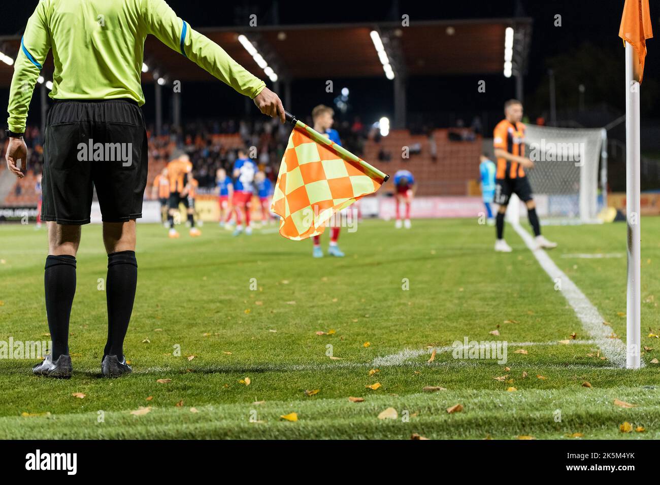 Soccer touchline referee with the flag shows corner during match at the football stadium Stock ...
