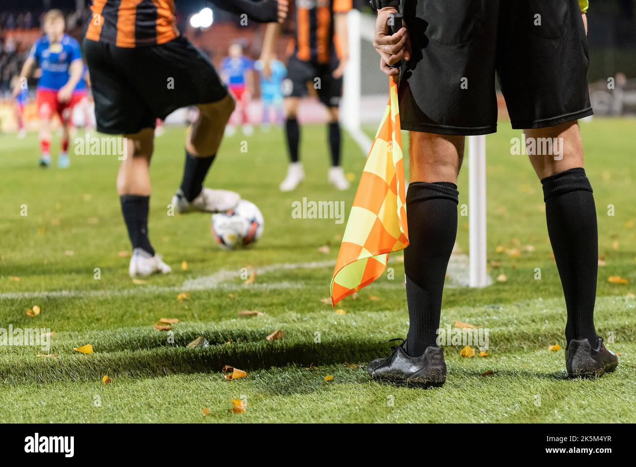 Footballer takes the corner. Detail of referee's legs during soccer ...