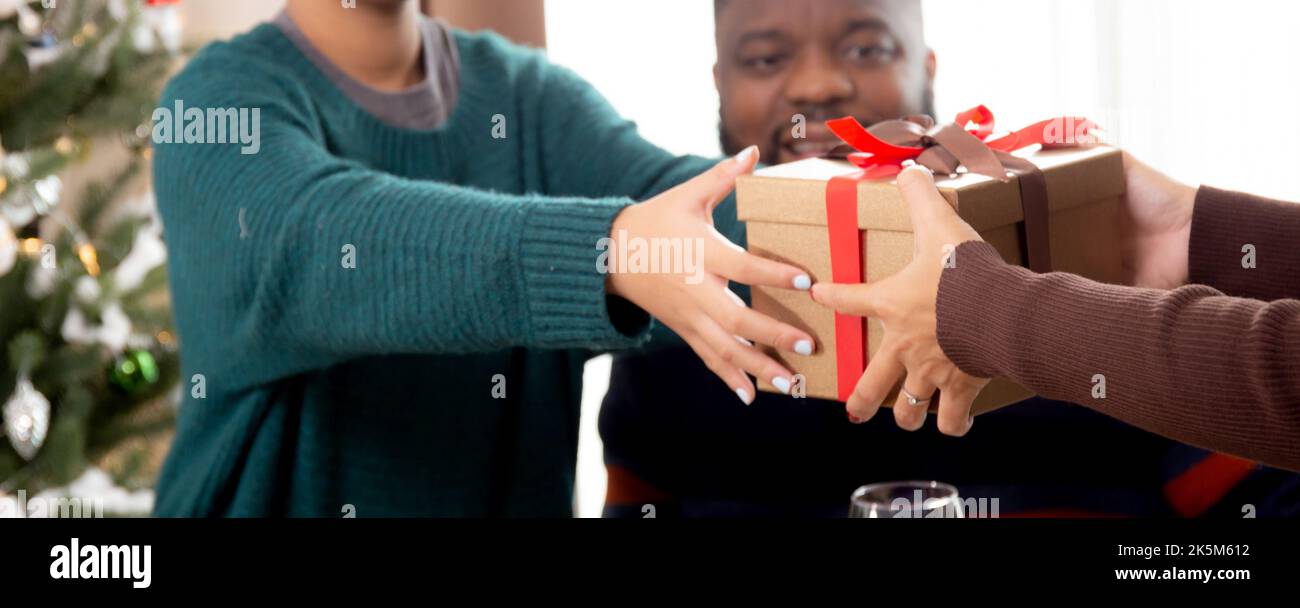 Happy family with mother giving gift box with daughter during dinner at ...